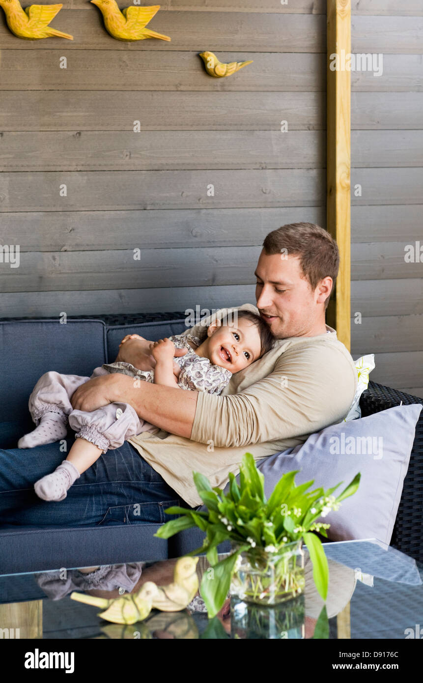 Father with toddler relaxing on sofa Stock Photo - Alamy