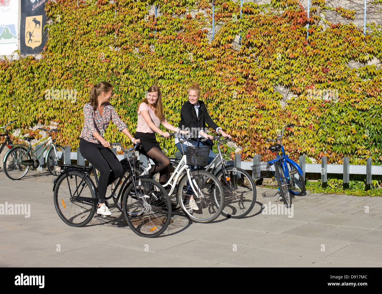 Smiling university students cycling Stock Photo - Alamy