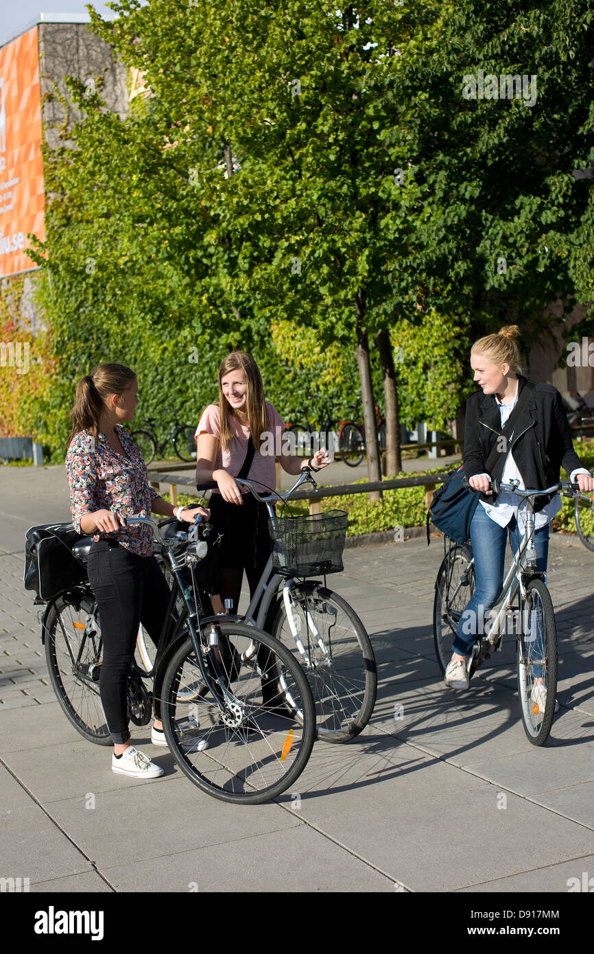 Smiling university students cycling Stock Photo - Alamy