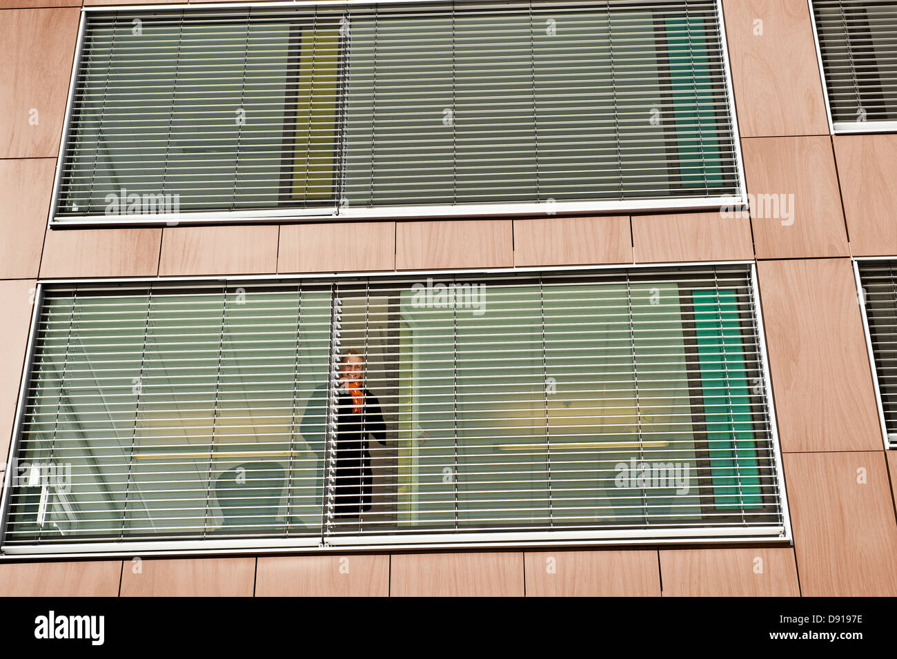 A young man in the window of an office building, Stockholm, Sweden ...