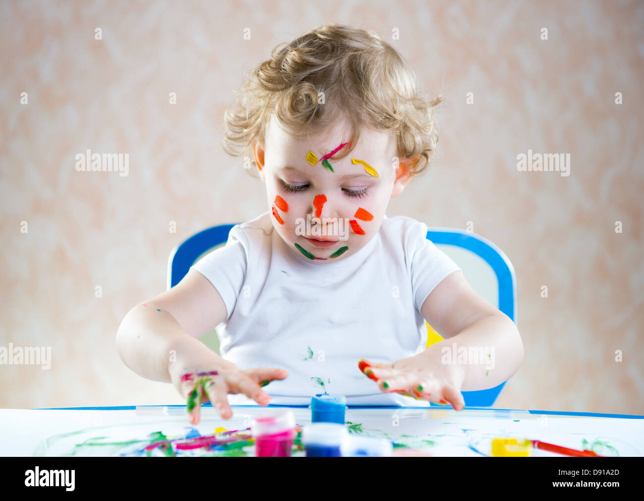 Cute little child painting with colorful paints Stock Photo - Alamy