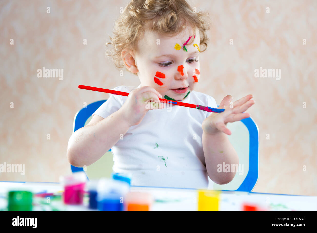 Cute little child painting with colorful paints Stock Photo - Alamy