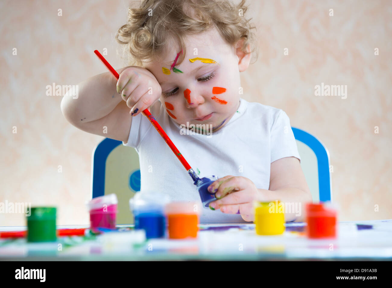 Cute little child painting with colorful paints Stock Photo - Alamy