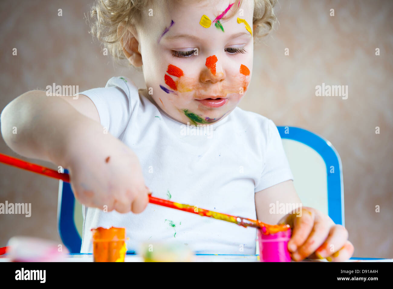 Cute little child painting with colorful paints Stock Photo - Alamy