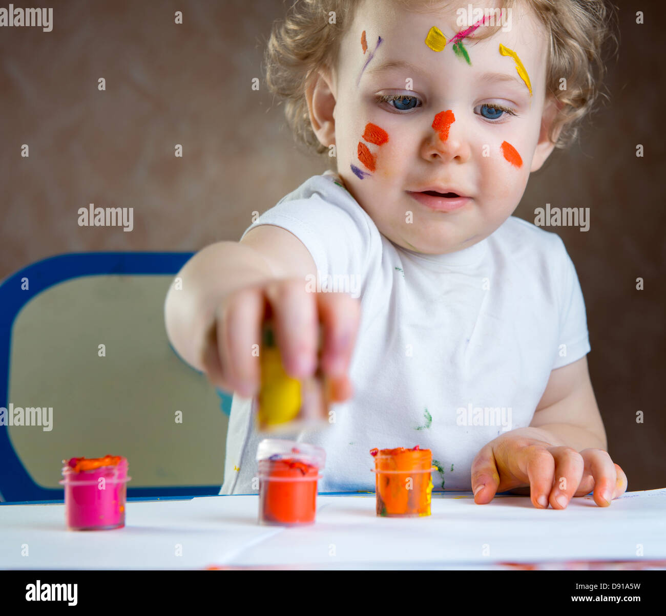 Cute little child painting with colorful paints Stock Photo - Alamy