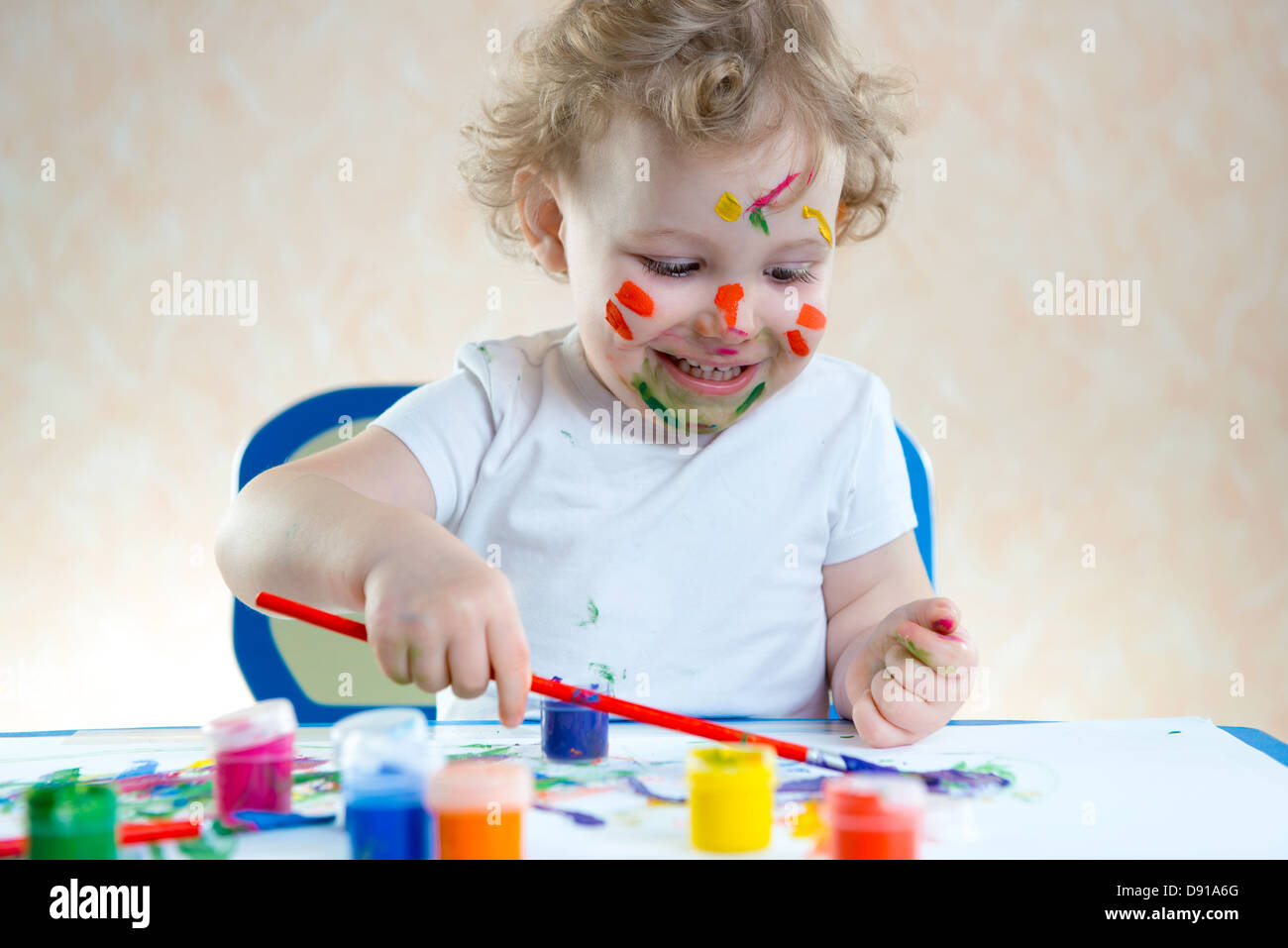 Cute little child painting with colorful paints Stock Photo - Alamy