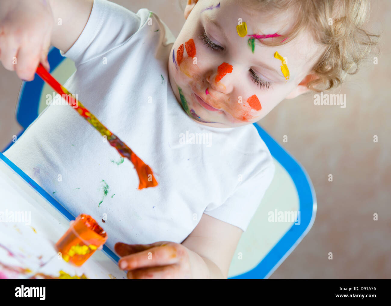 Cute little child painting with colorful paints Stock Photo - Alamy