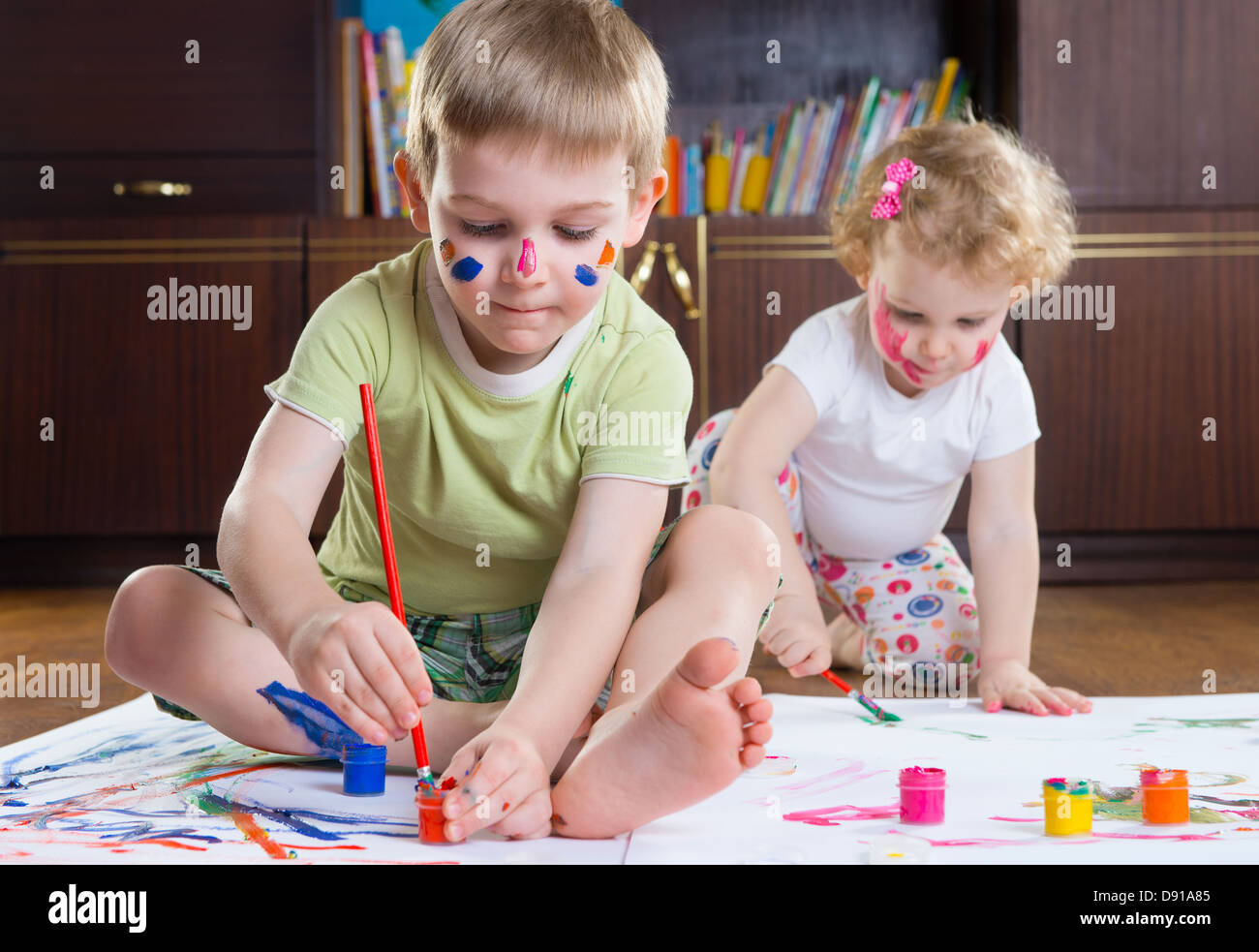 Two cute kids painting with colorful paints Stock Photo - Alamy