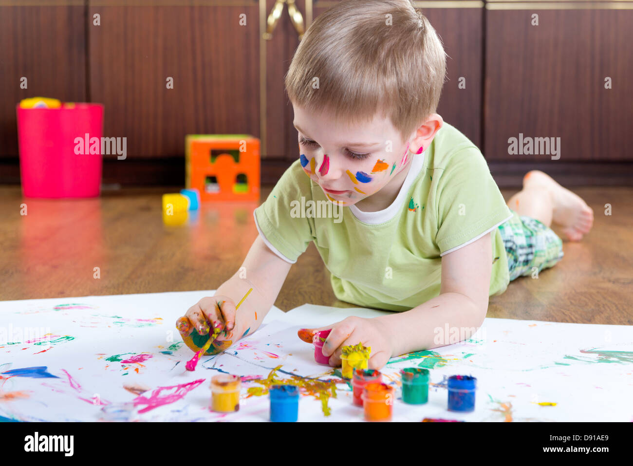 Cute little boy painting with colorful paints Stock Photo - Alamy