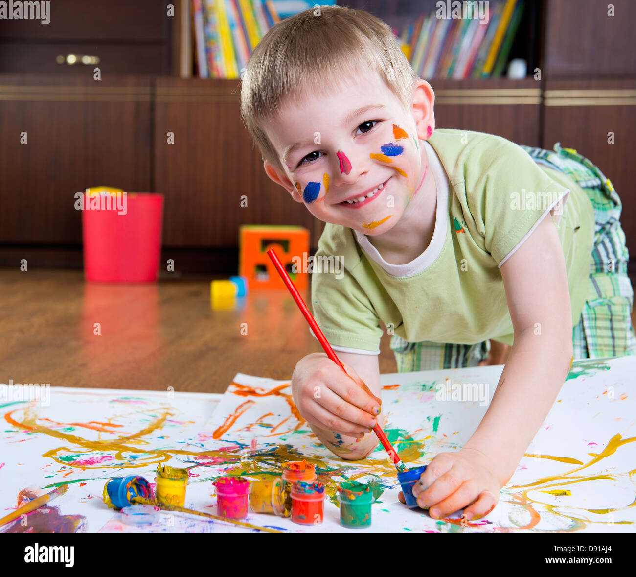 Excited little boy painting with colorful paints Stock Photo - Alamy