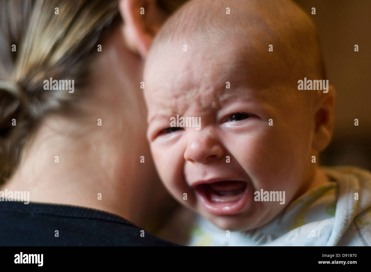 A mother carries her crying baby Stock Photo - Alamy