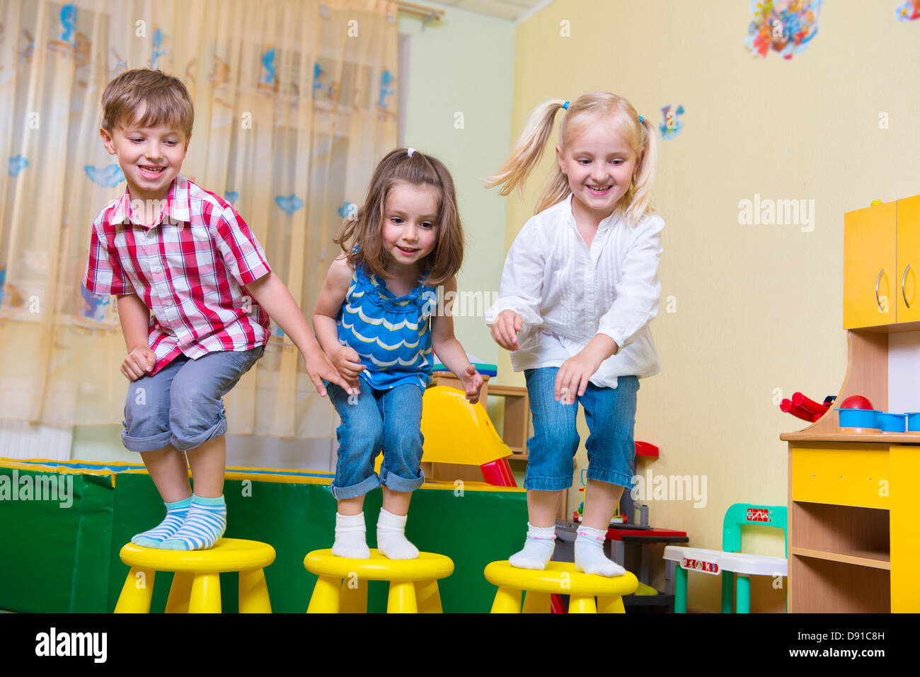 Group of happy preschool kids jumping in kindergarten Stock Photo - Alamy