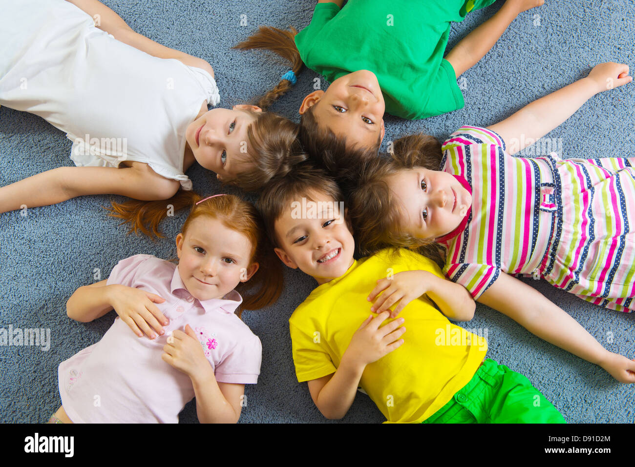 Cute little children lying on floor in kindergarten Stock Photo - Alamy
