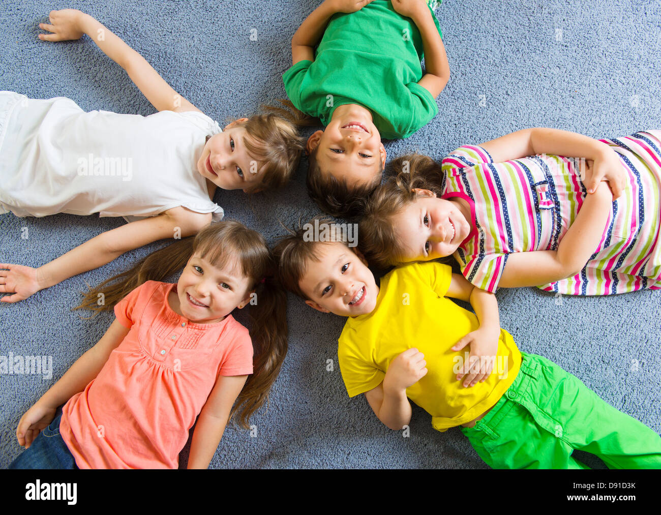 Cute little children lying on floor in kindergarten Stock Photo - Alamy