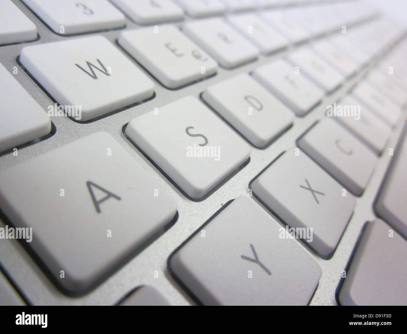 A Mac keyboard in white and silver, known for its sleek design and ...