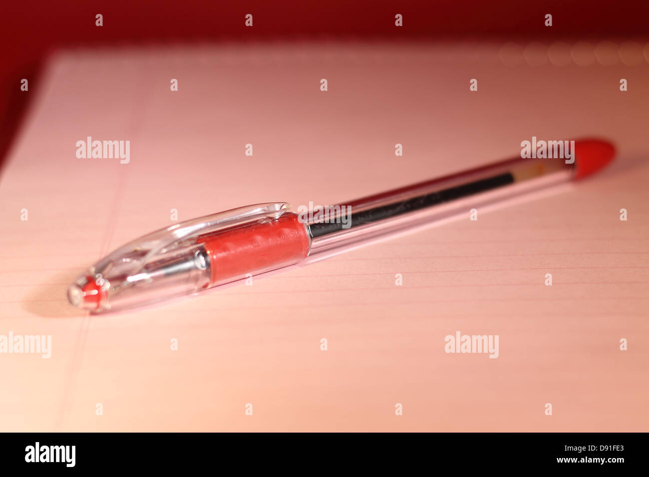 Red pen on light pink notepad Stock Photo - Alamy
