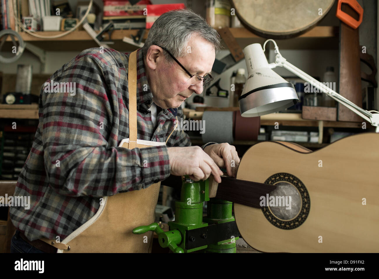 Guitar maker finishing acoustic guitar in workshop Stock Photo - Alamy