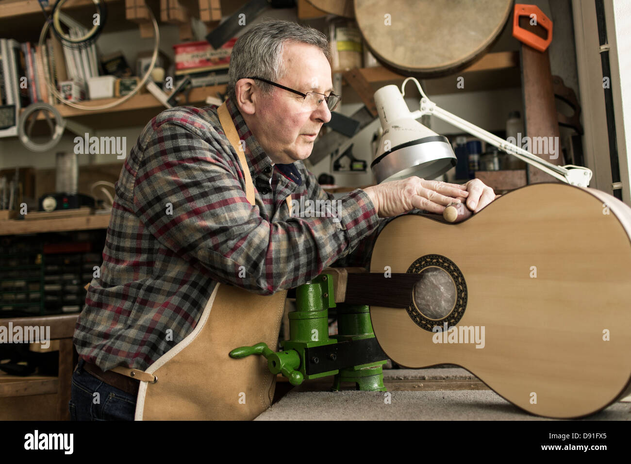 Guitar maker finishing acoustic guitar in workshop Stock Photo - Alamy