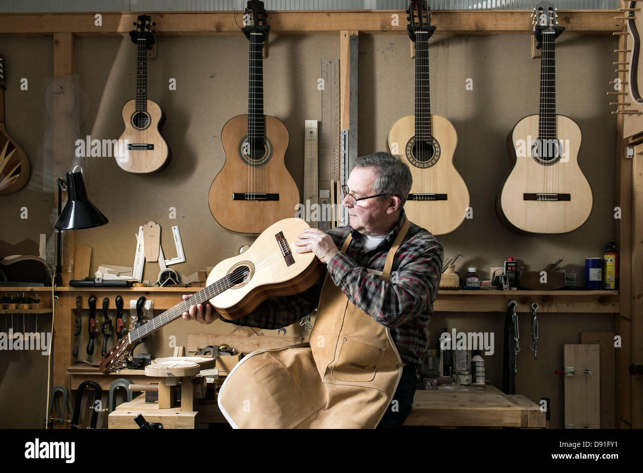 Guitar maker finishing acoustic guitar in workshop Stock Photo - Alamy