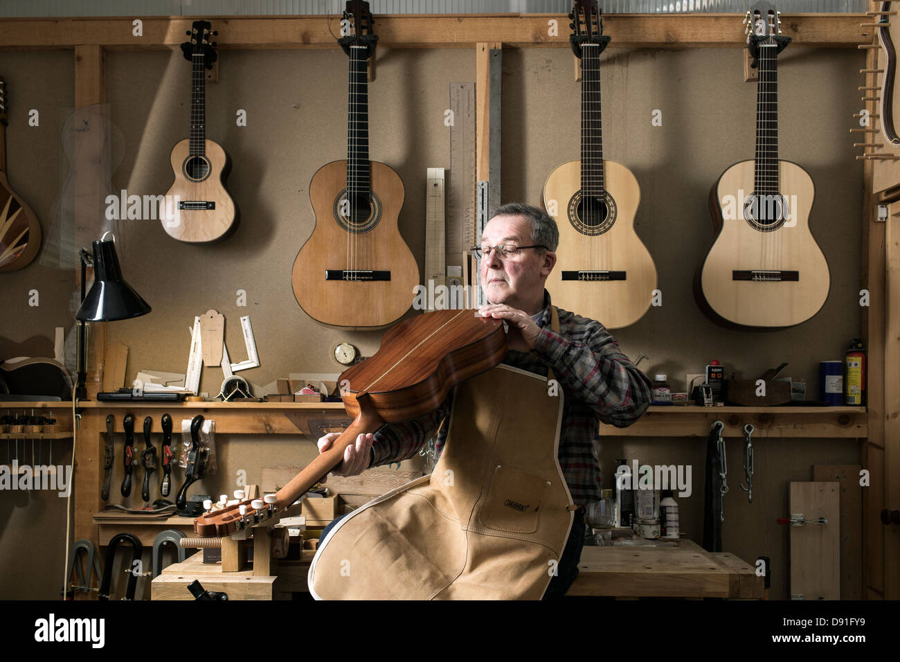 Guitar maker finishing acoustic guitar in workshop Stock Photo - Alamy
