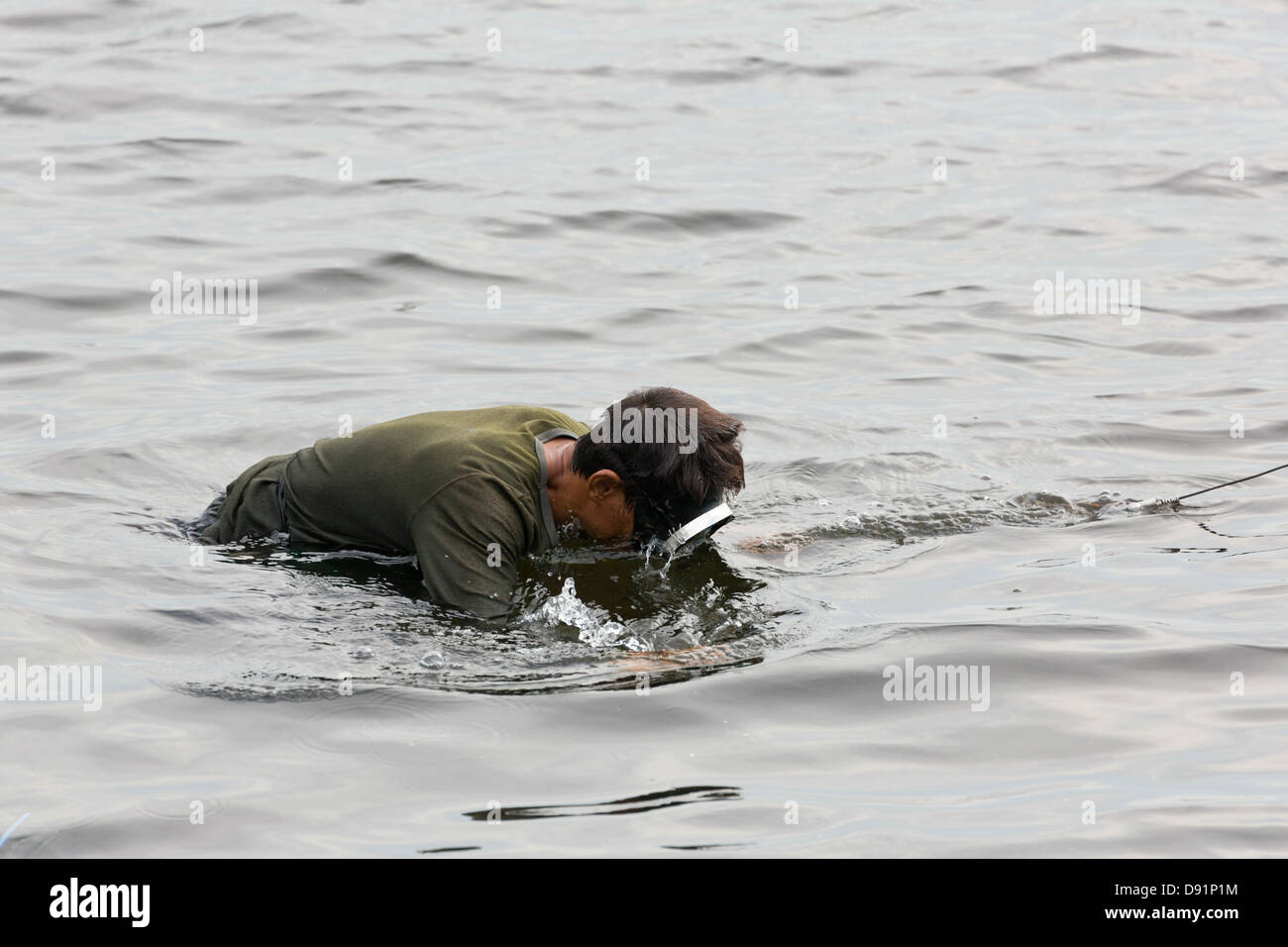 Fisherman diving in the Manila Bay, Philippines Stock Photo - Alamy