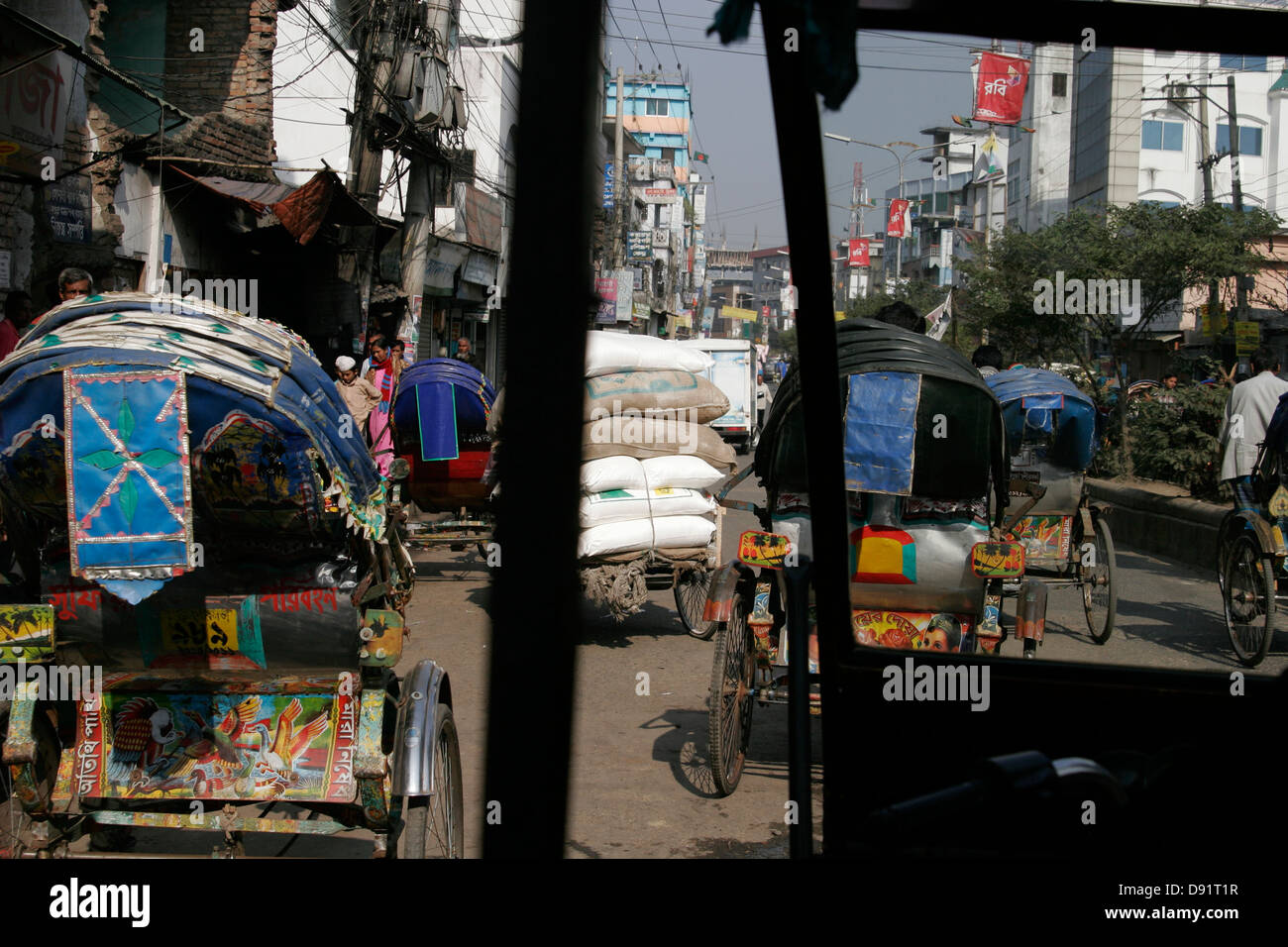 View from CNG (motor taxi) passing on the street full of rickshaws ...