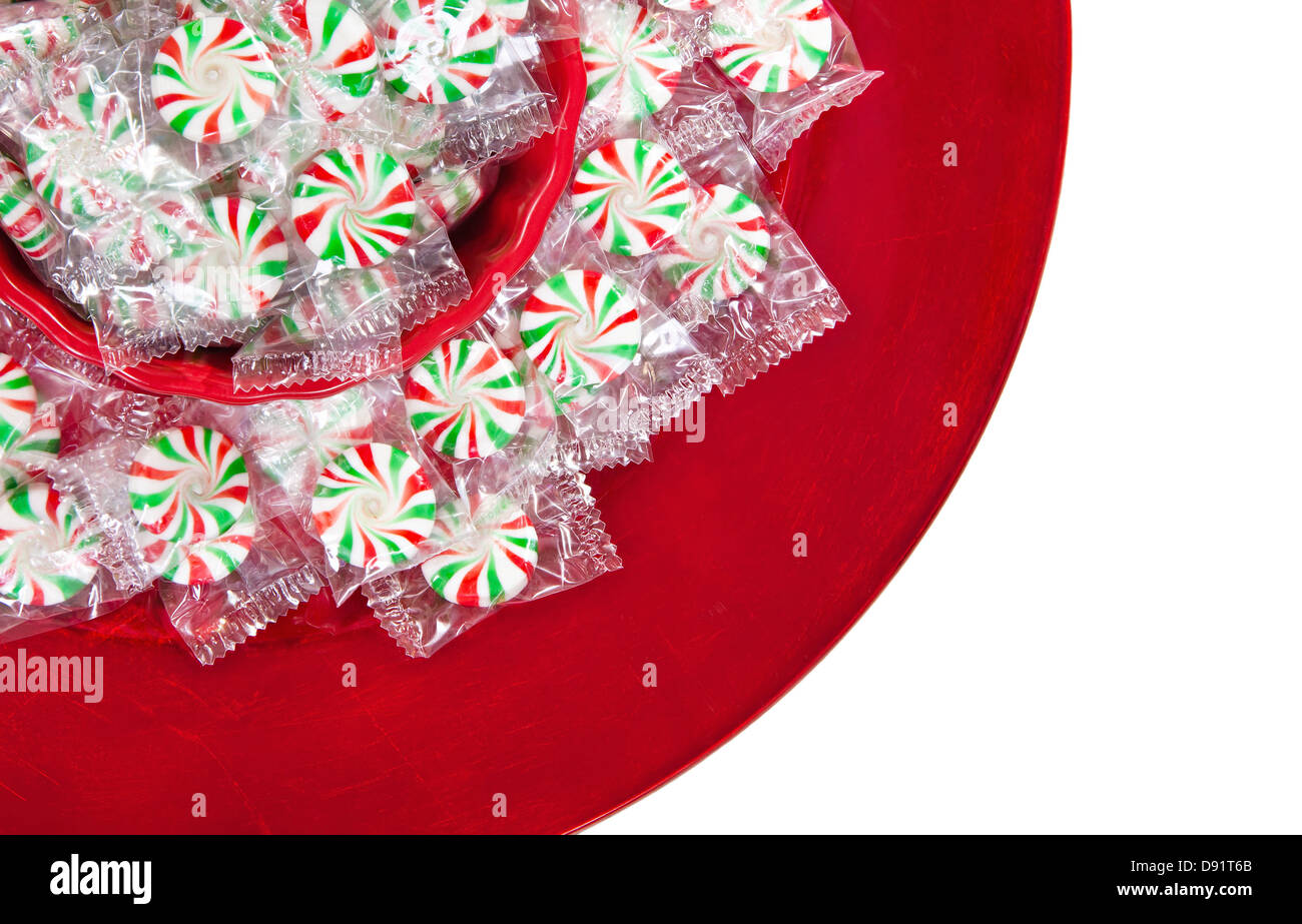 Pinwheel Christmas candies displayed in red bowl and plate over white ...