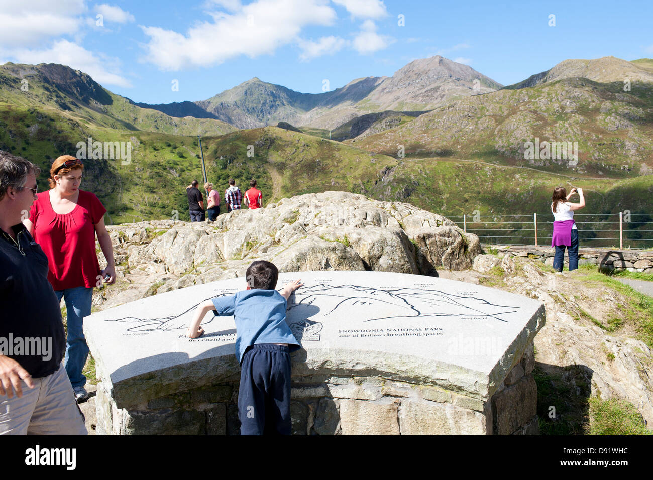Visitors take in the view and look at the relief map of mount Snowdon ...