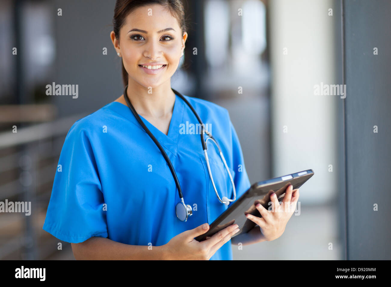 beautiful young female medical intern with tablet computer in office ...