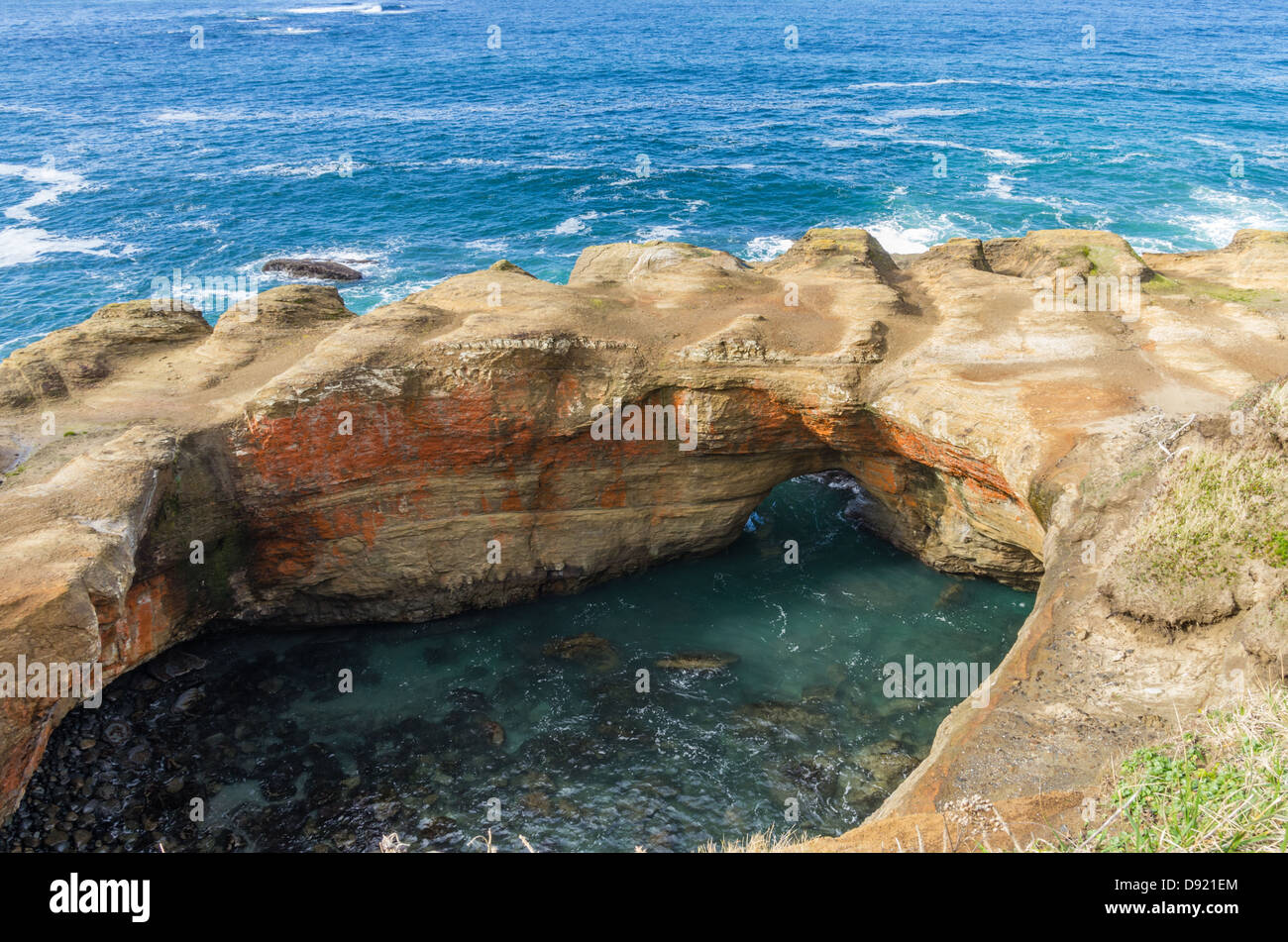 Oregon, Otter Rock, Devils Punch Bowl State Park. Water washes through ...