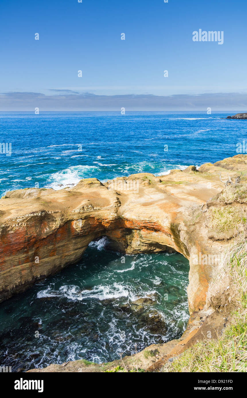 Oregon, Otter Rock, Devils Punch Bowl State Park. Water washes through ...