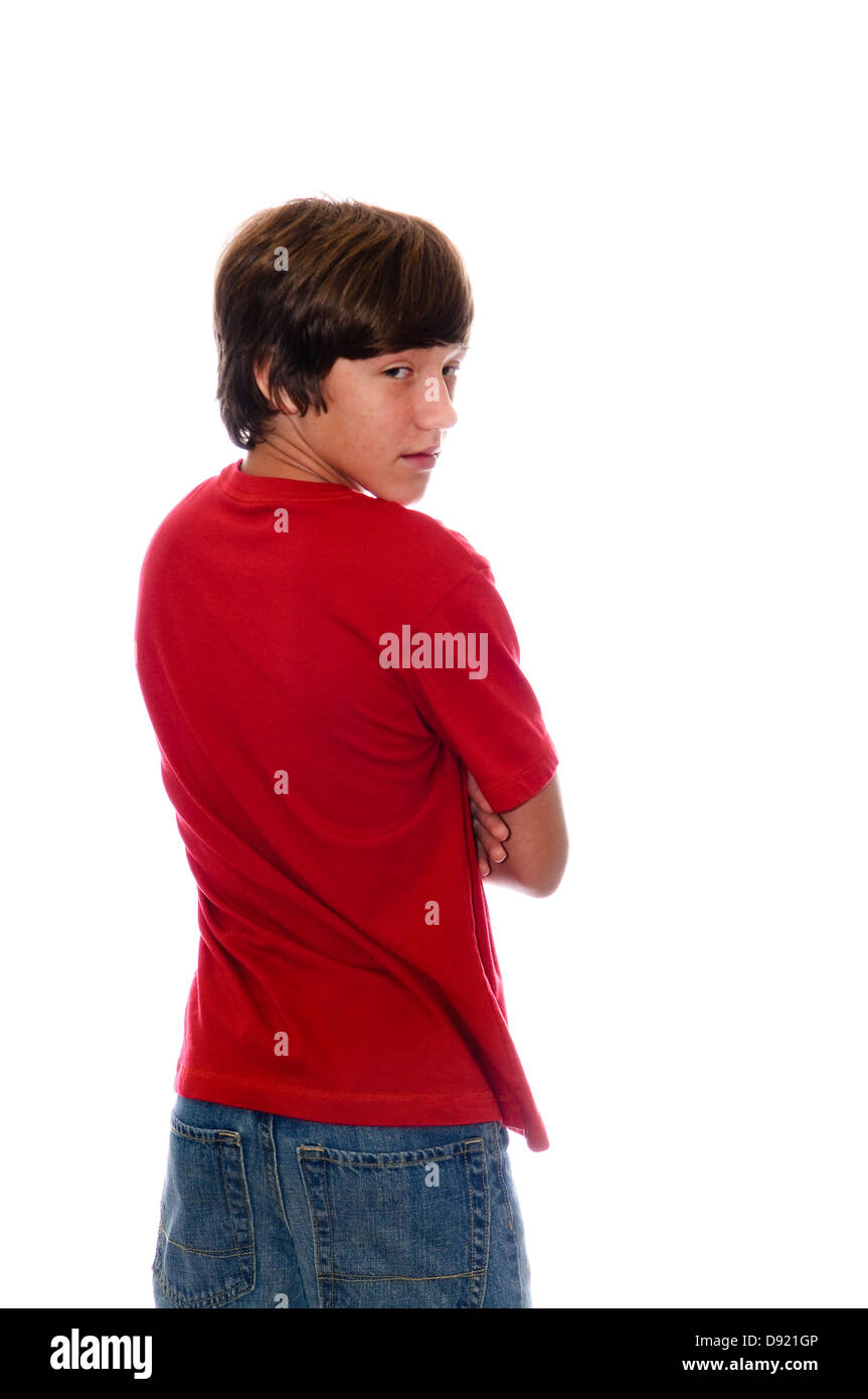 a young teen boy in a red shirt looking backward over his shoulder ...