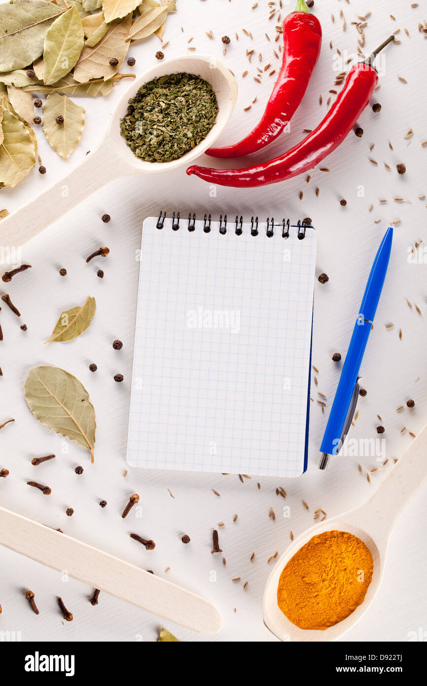 notebook and pen to write recipes around hot red pepper with spices on ...