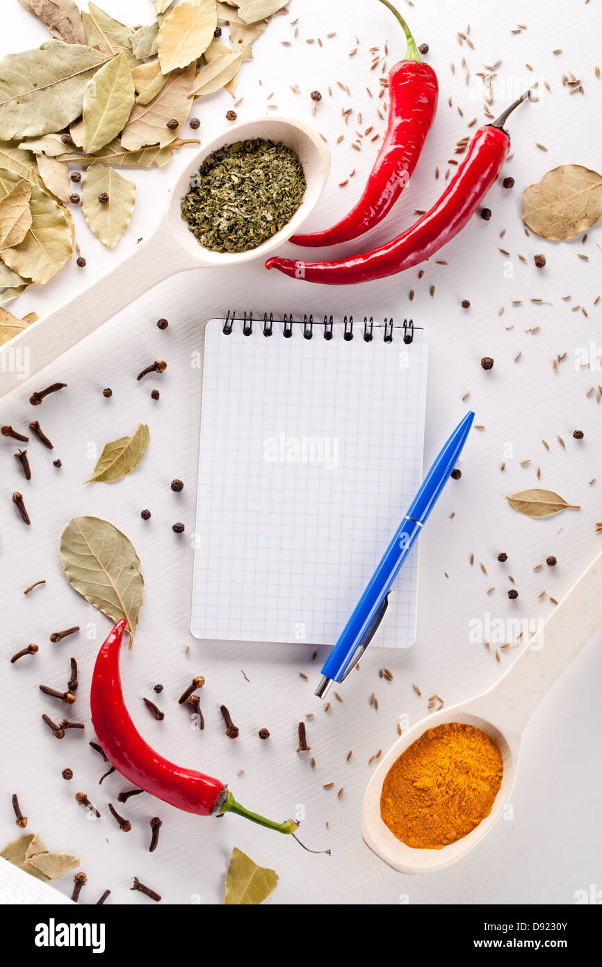 notebook and pen to write recipes around hot red pepper with spices on ...