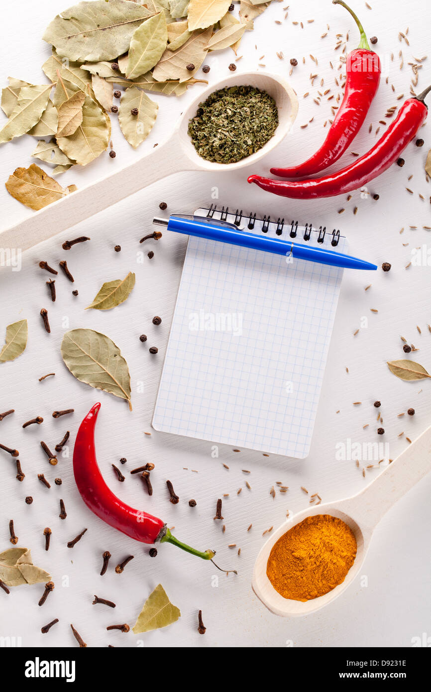 notebook and pen to write recipes around hot red pepper with spices on ...
