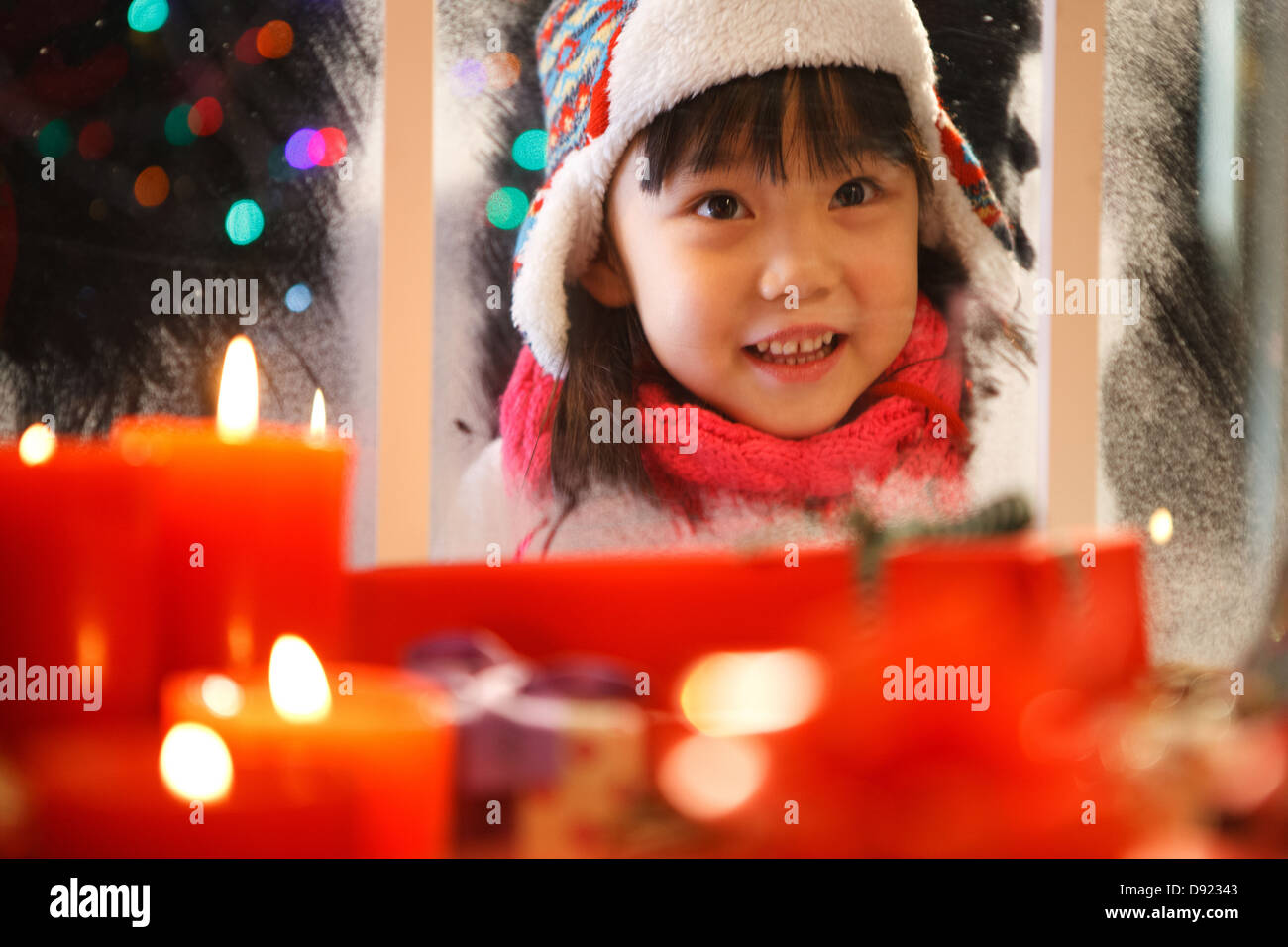 Girl looking at Christmas gift through window Stock Photo - Alamy