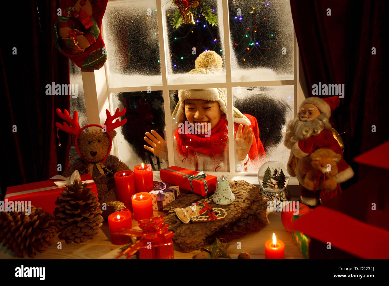 Boy looking at Christmas gift through window Stock Photo - Alamy