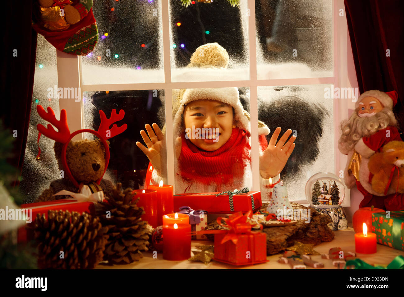 Boy looking at Christmas gift through window Stock Photo - Alamy