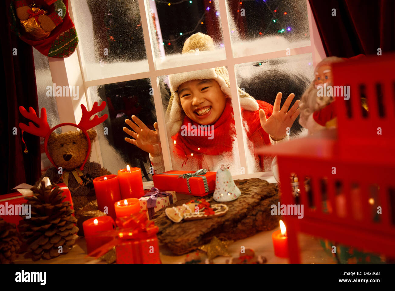 Boy looking at Christmas gift through window Stock Photo - Alamy