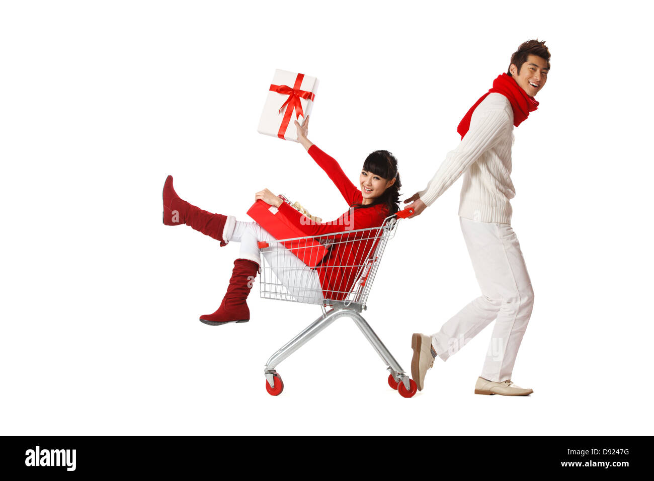 Young man pulling young woman in shopping cart Stock Photo - Alamy