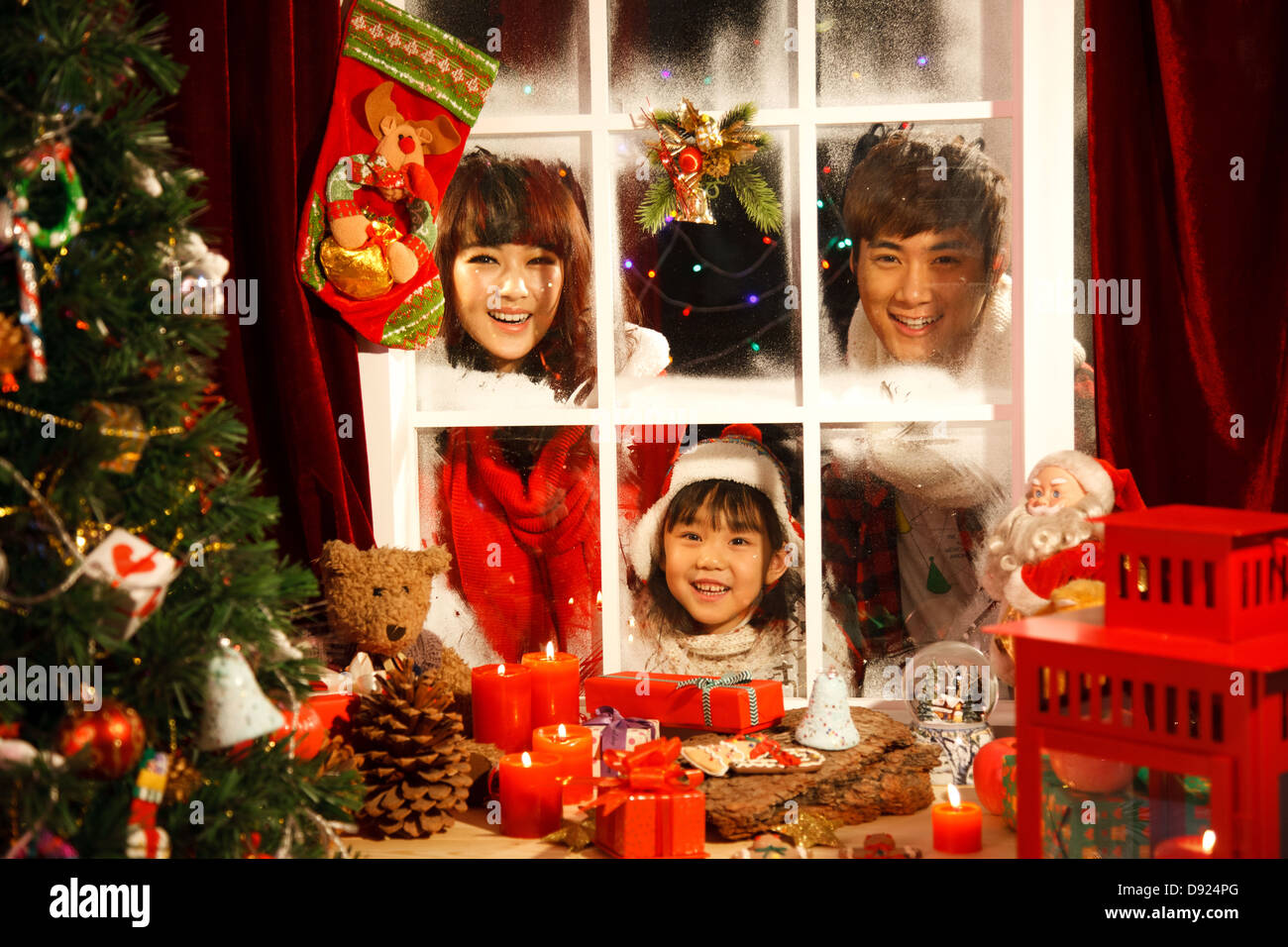 Family looking at Christmas gift through window Stock Photo - Alamy