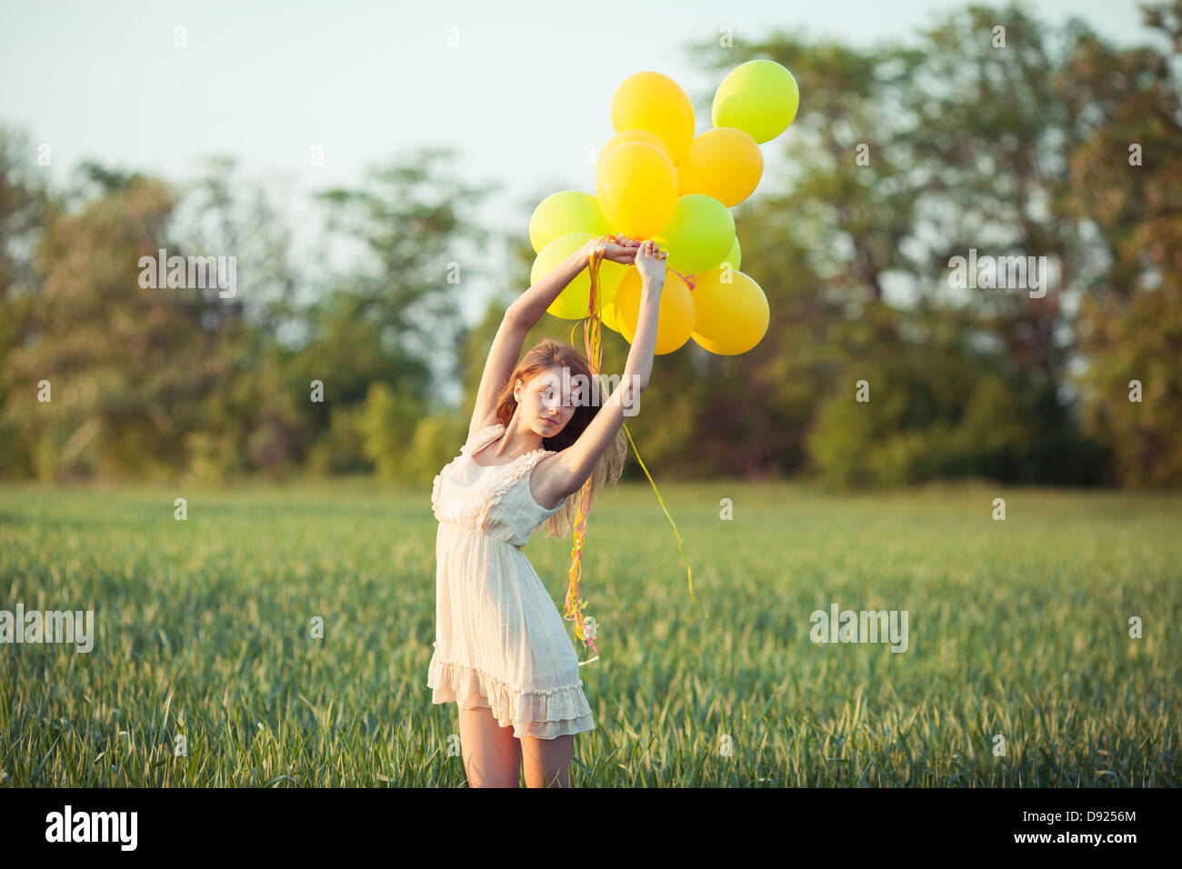 young beautiful girl with baloons in the field Stock Photo - Alamy
