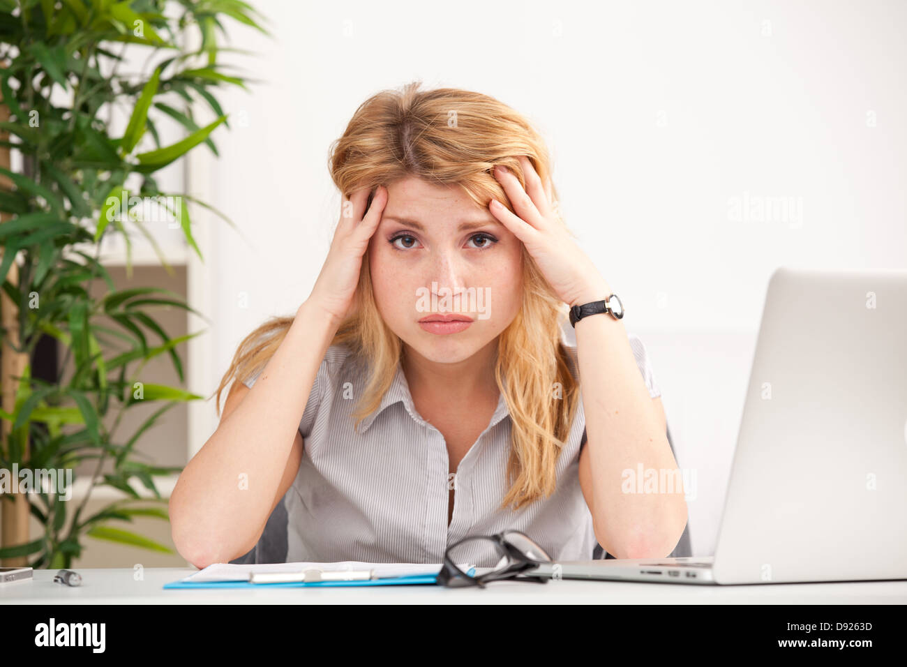 tired young woman on the laptop having some problems in the office ...