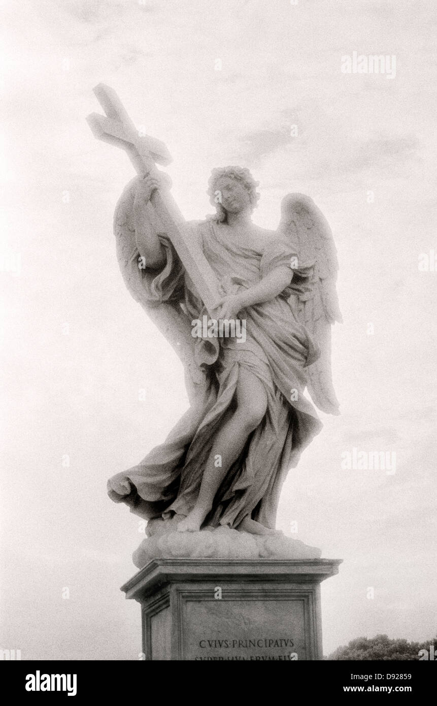 Statue of an angel holding a cross sculpted by Bernini on the Bridge of ...