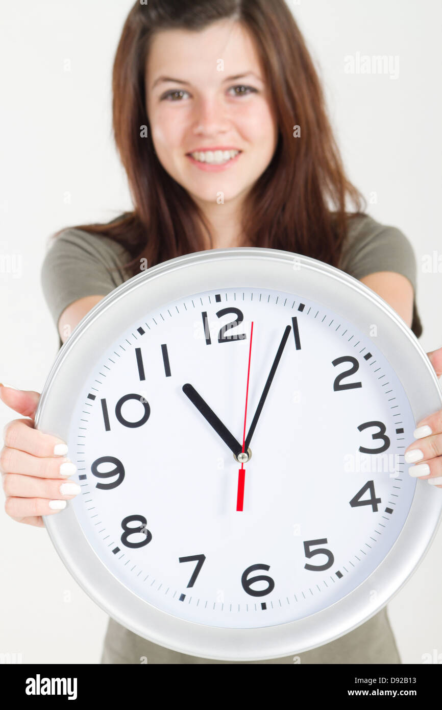 time concept: beautiful teen girl holding big clock over white Stock ...