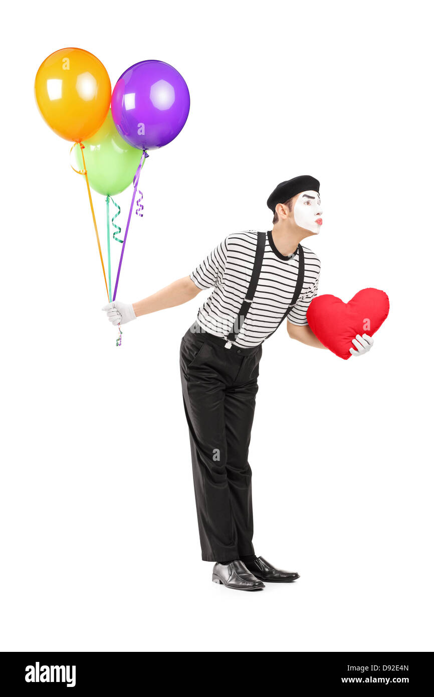 Full length portrait of a young mime artist with balloons and red heart ...