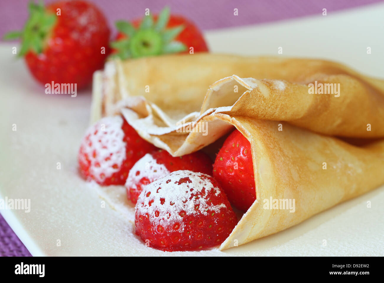 Crepe with strawberries dusted with icing sugar Stock Photo - Alamy