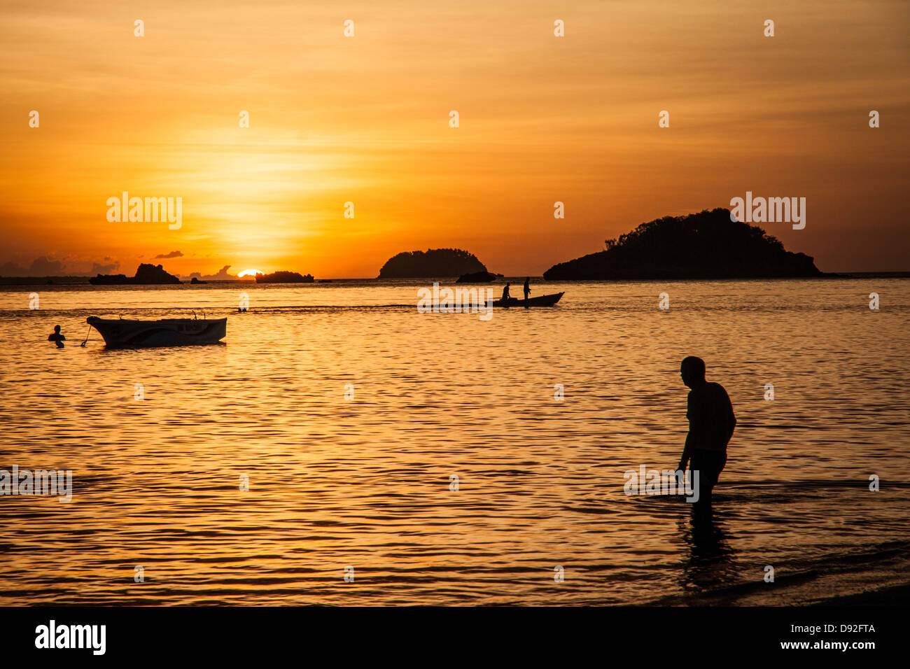 Sunset behind a swimmer on Bounty Beach Stock Photo - Alamy
