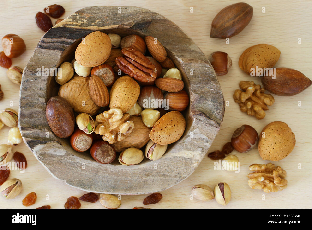 Nut variety in teak root bowl Stock Photo - Alamy
