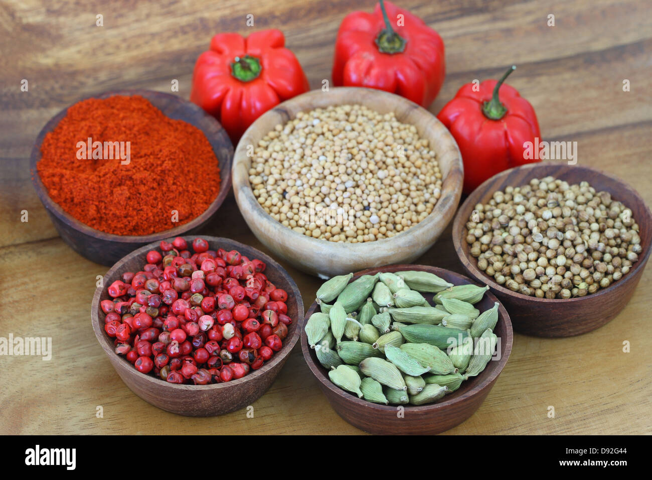 Mixed spices and round hot peppers on wooden background Stock Photo - Alamy